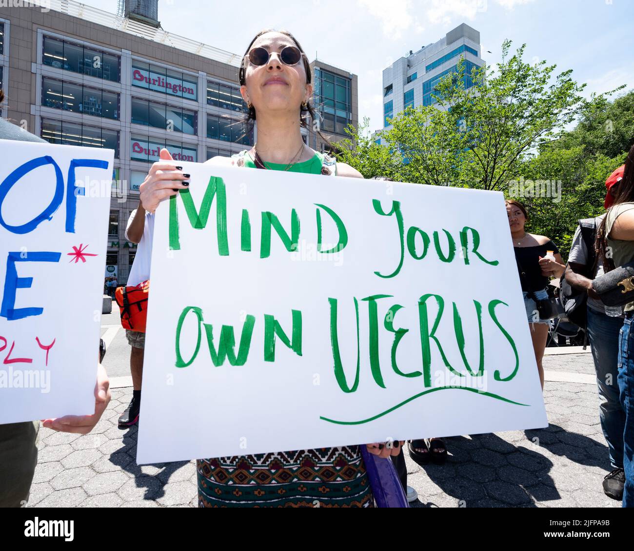 New York City. US, 04/07/2022, Woman holding a sign saying "Mind your ...