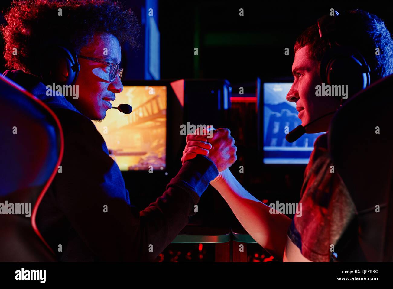 Side view of cyber sports team huddling in unity with video game ...