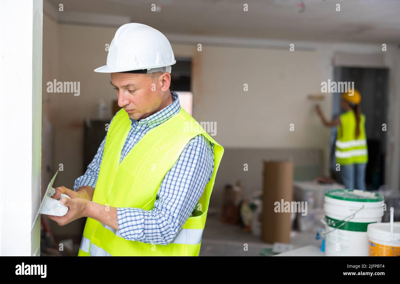 Skilled man plasterer working at renovating object Stock Photo - Alamy