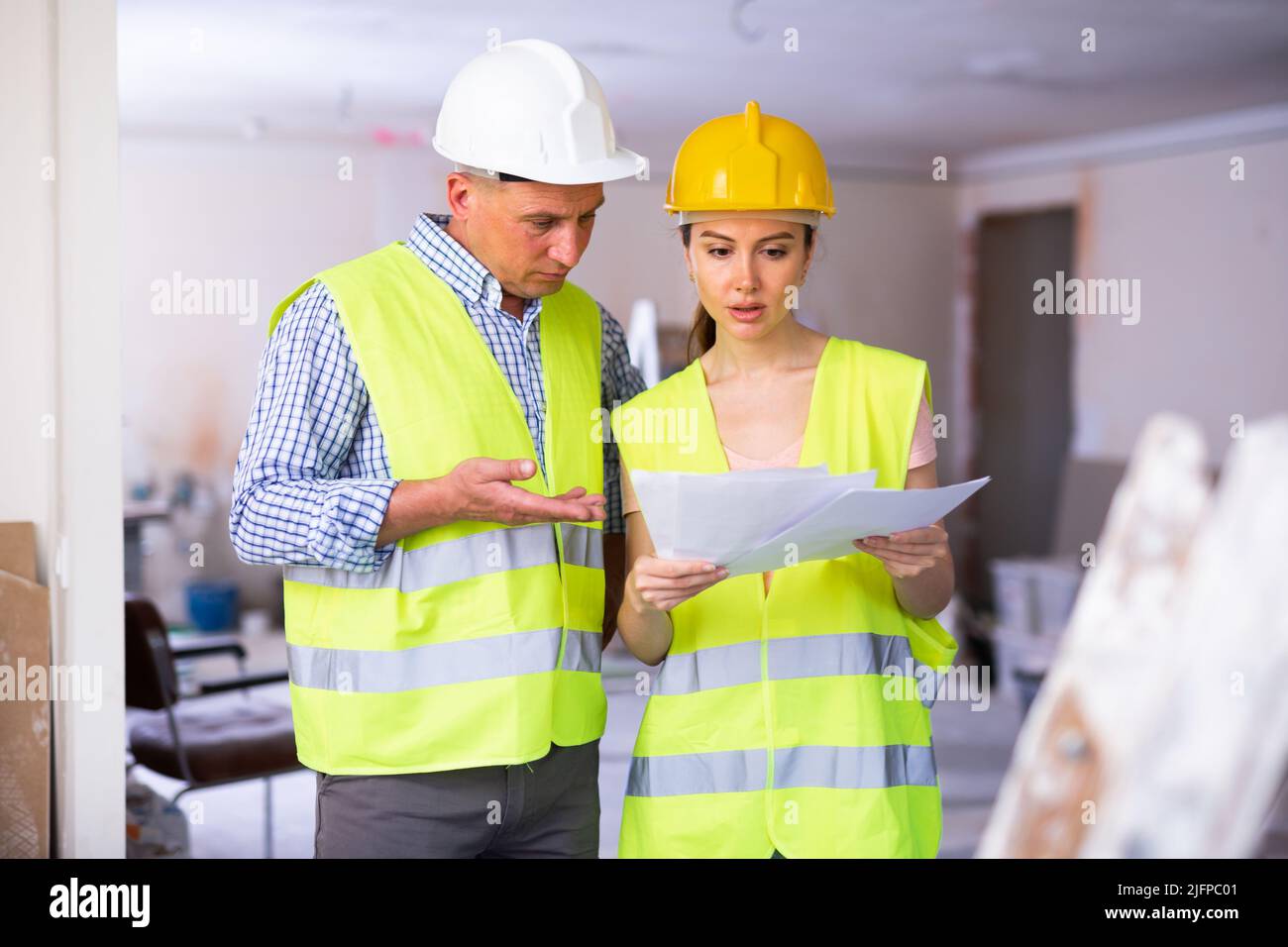 Builders having conversation about work plan in apartment Stock Photo ...