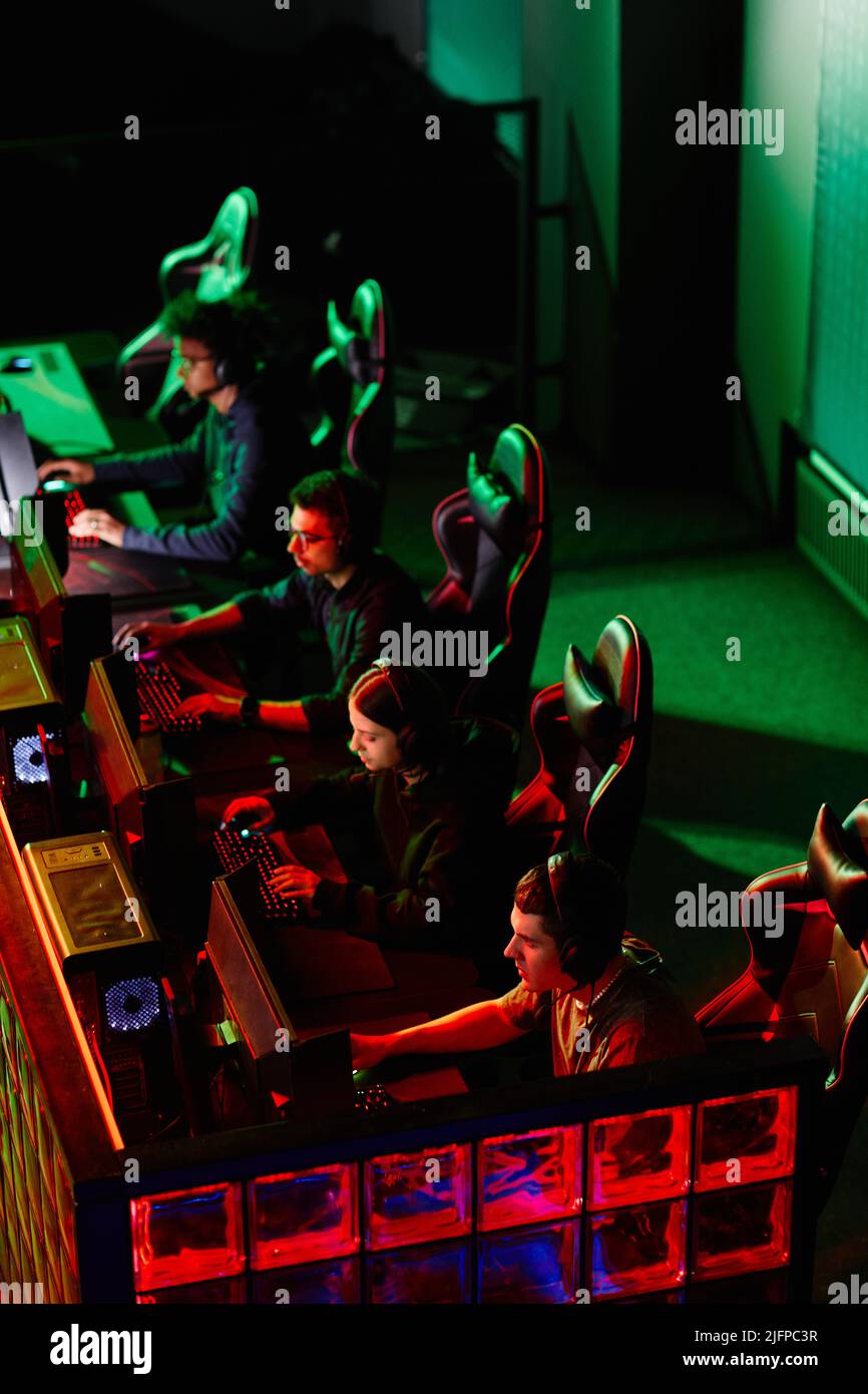 Top view at diverse eSports team playing video games in row with neon ...