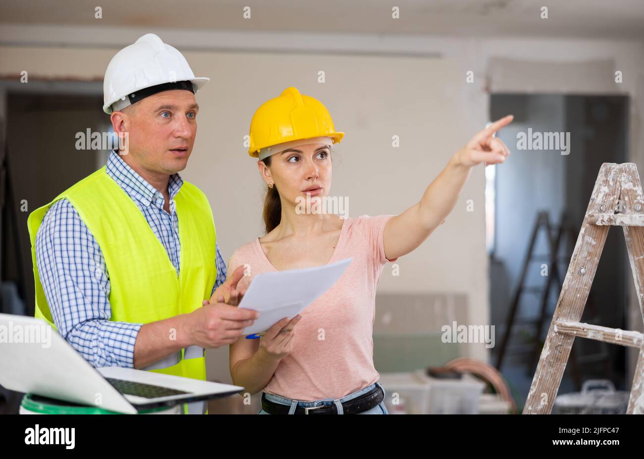 Man and woman builders talking in house Stock Photo - Alamy