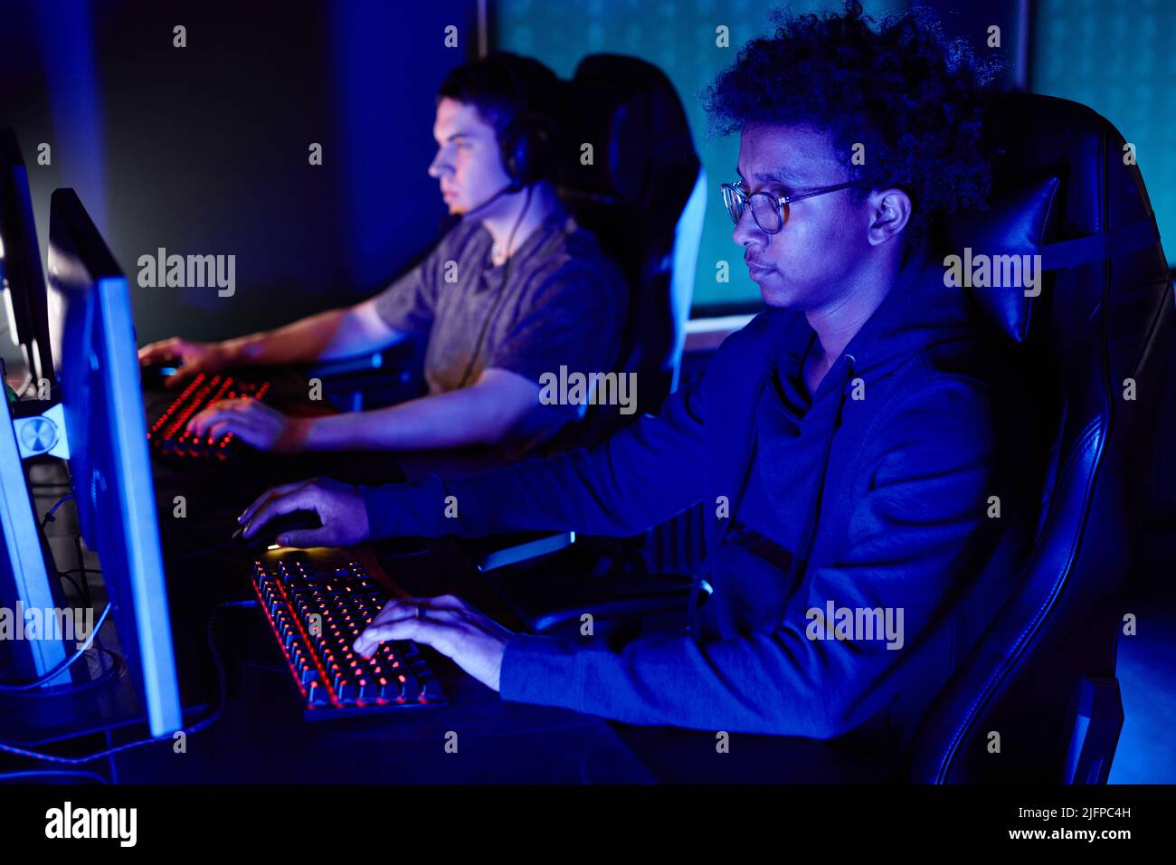 Side view portrait of young black man playing video games in ...