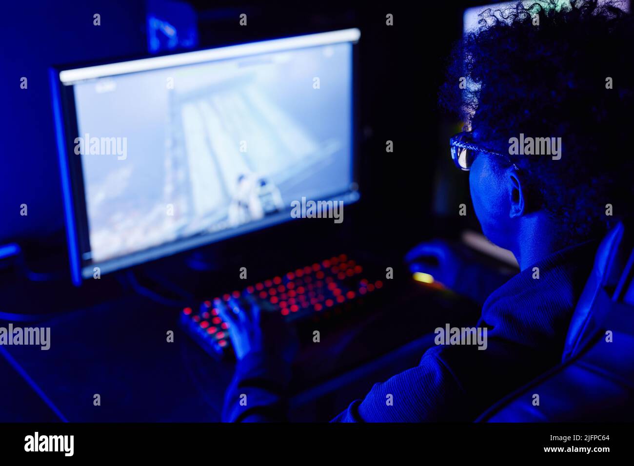 Over shoulder view of young black man playing video games in ...