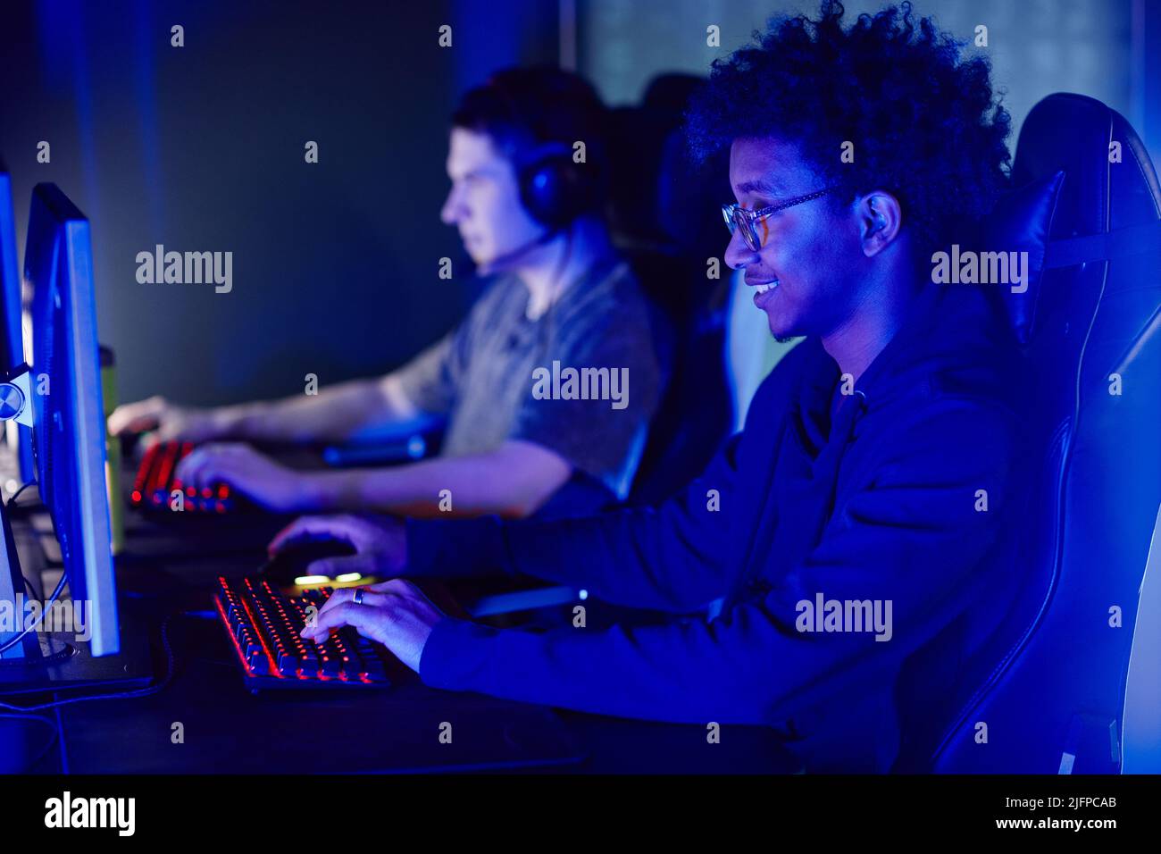 Side view portrait of smiling African American man playing video games ...