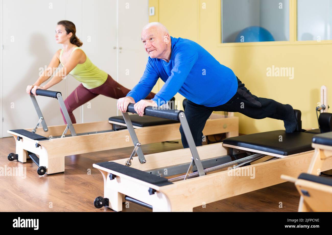 Elderly man press exercises on pilates reformer at studio Stock Photo ...