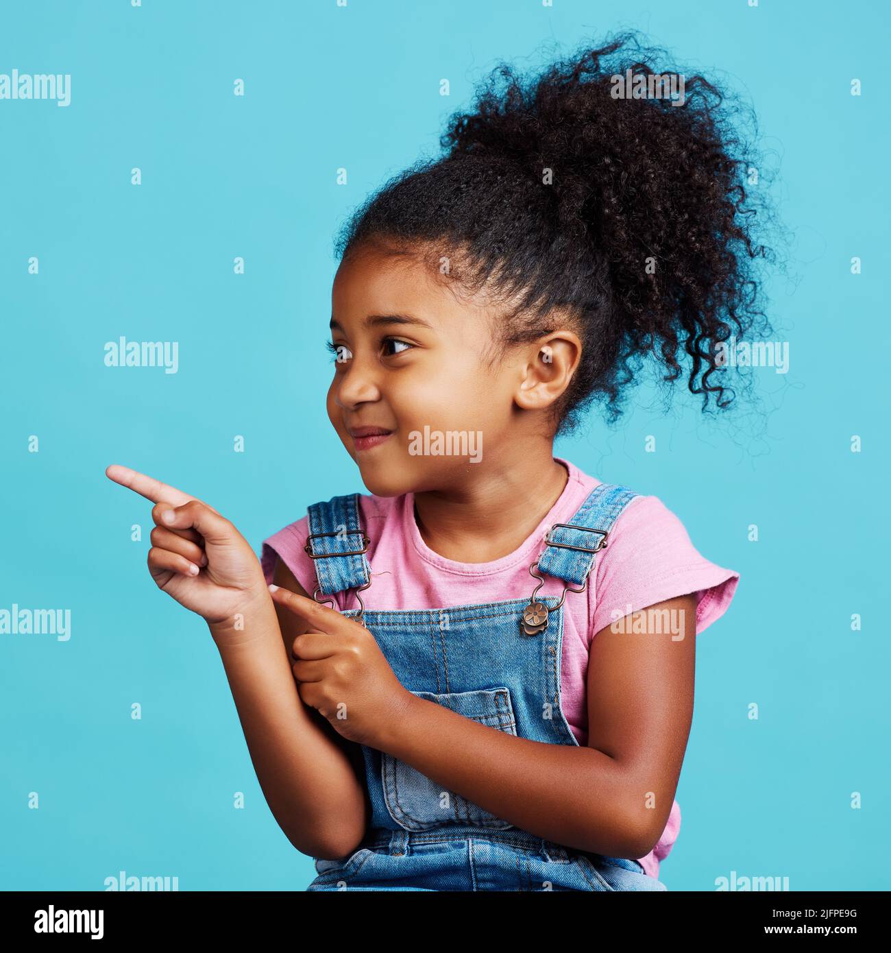 Im telling everyone. Shot of an adorable little girl pointing at ...