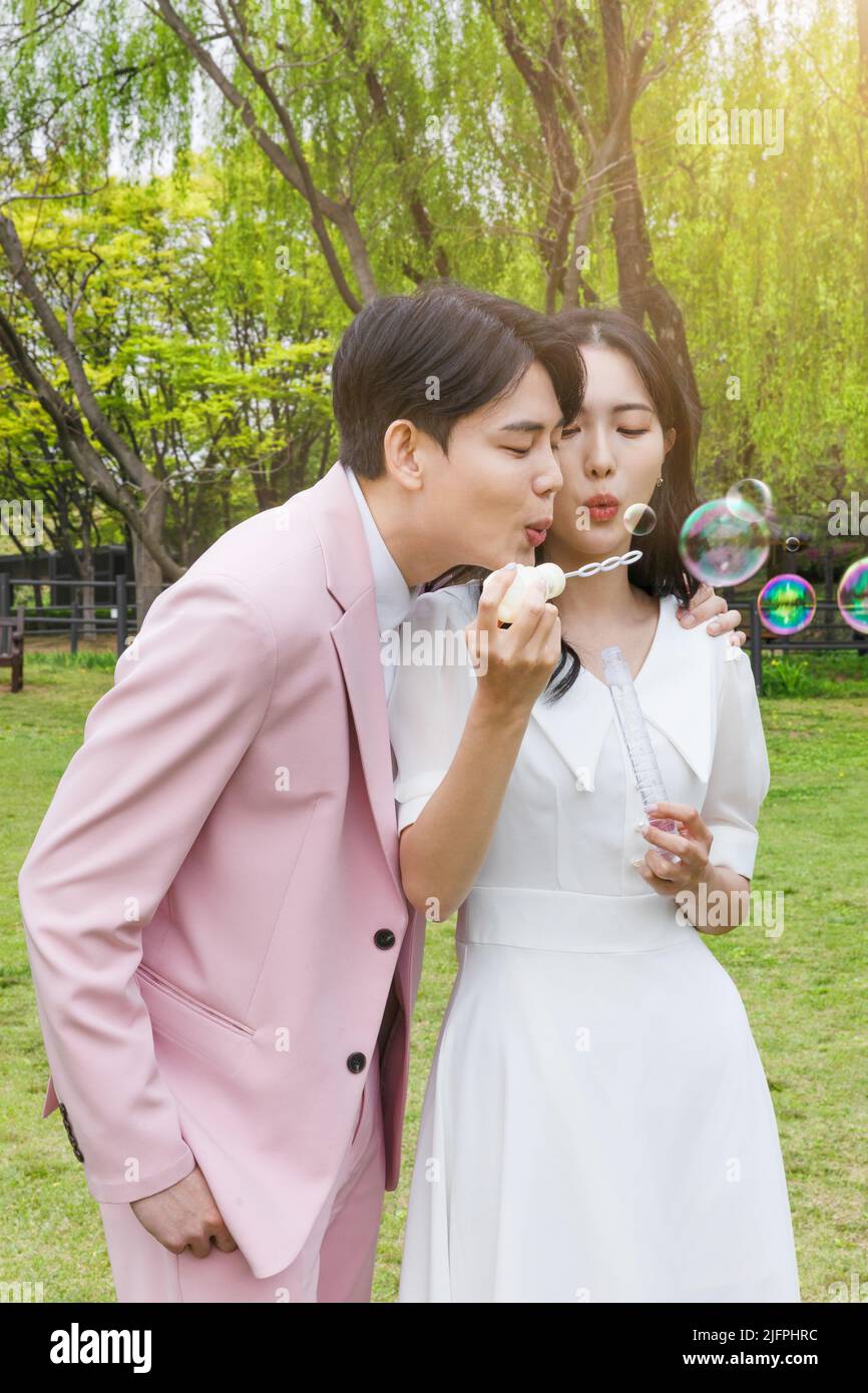 Korean Asian couple self small wedding concept in spring blowing soap ...