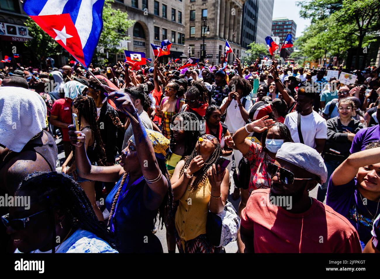 Parade revelers wave the Cuban and Haitian flags. Since 1975 the ...