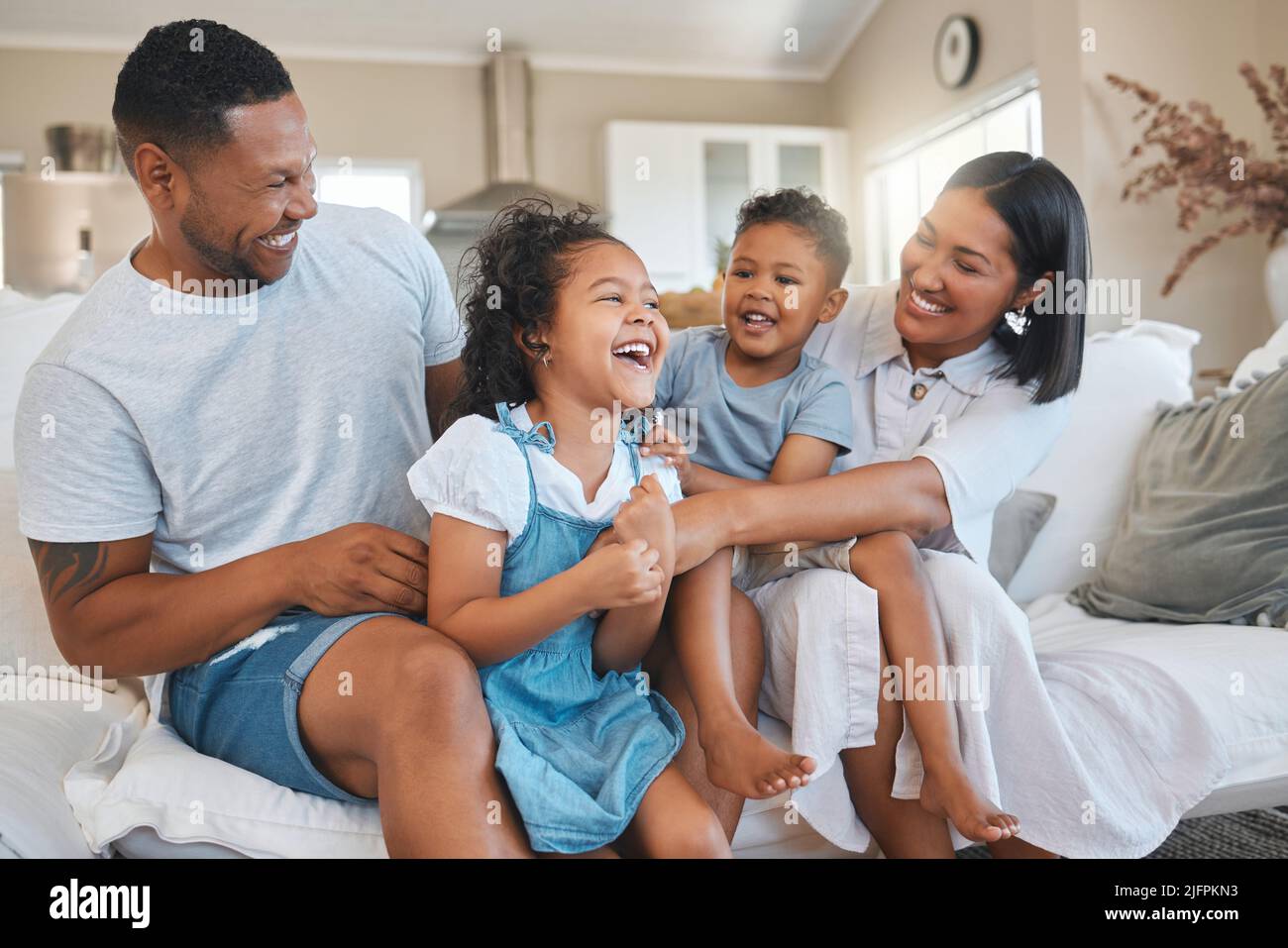 Mom turns into a tickle monster. Shot of a young family happily bonding ...