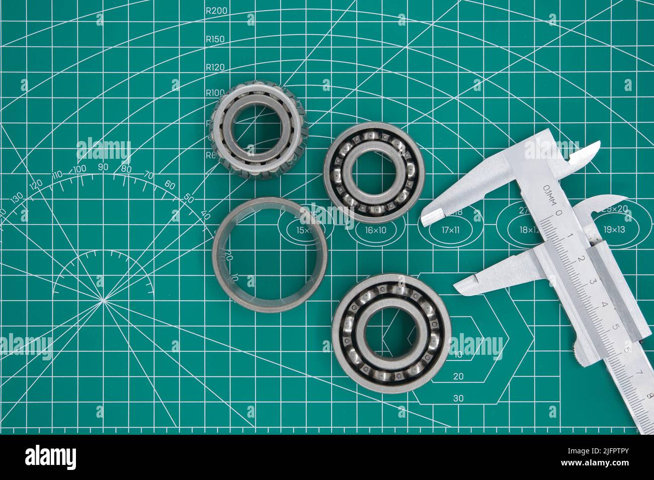 Tapered roller bearings or ball bearings and caliper on green cutting ...