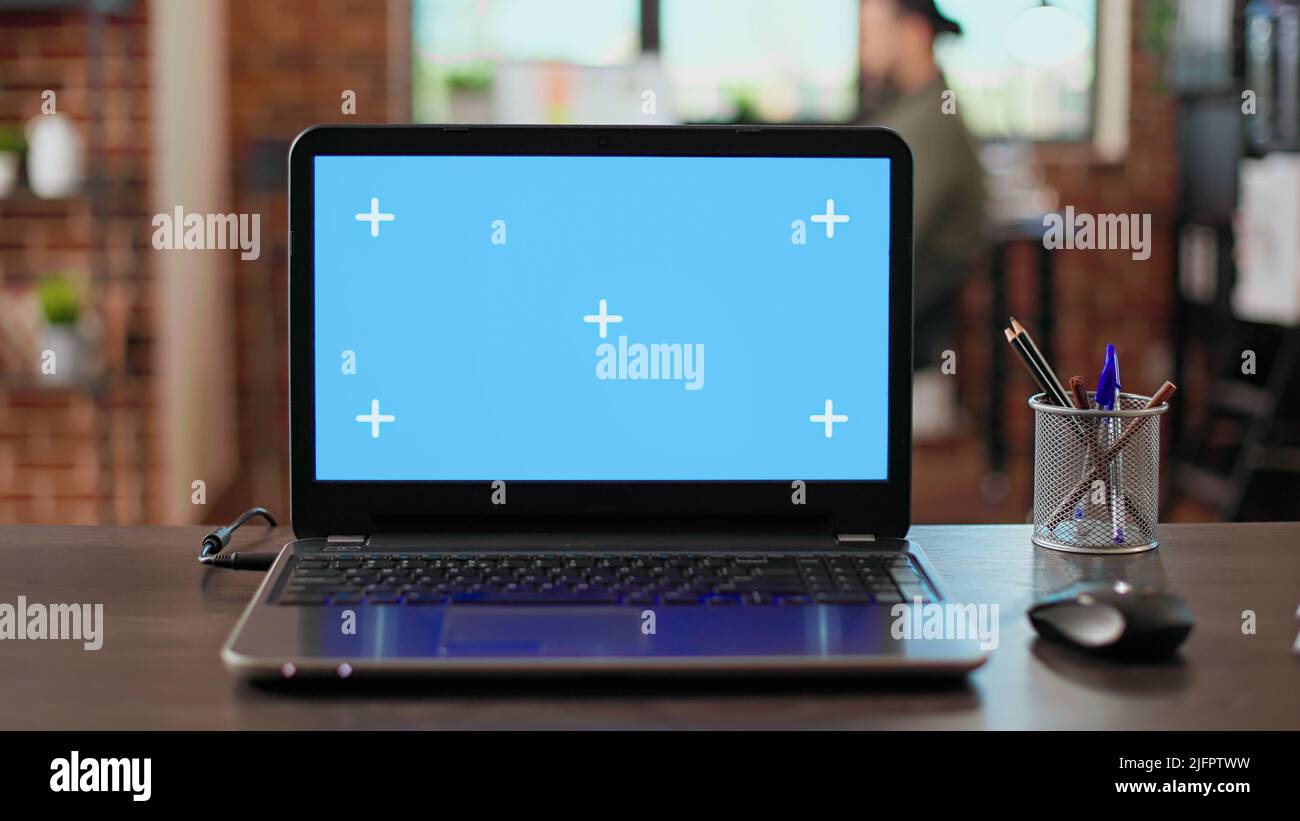 Empty office desk with greenscreen display on wireless laptop, used by ...