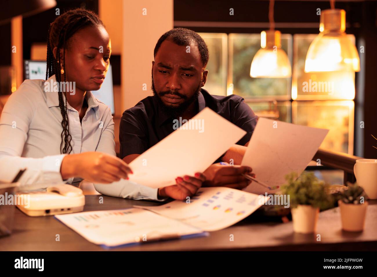 Team of business partners brainstorming ideas to plan report, doing project research with data ...