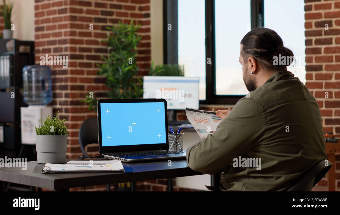 Office Worker Using Laptop With Greenscreen Display At Job Working