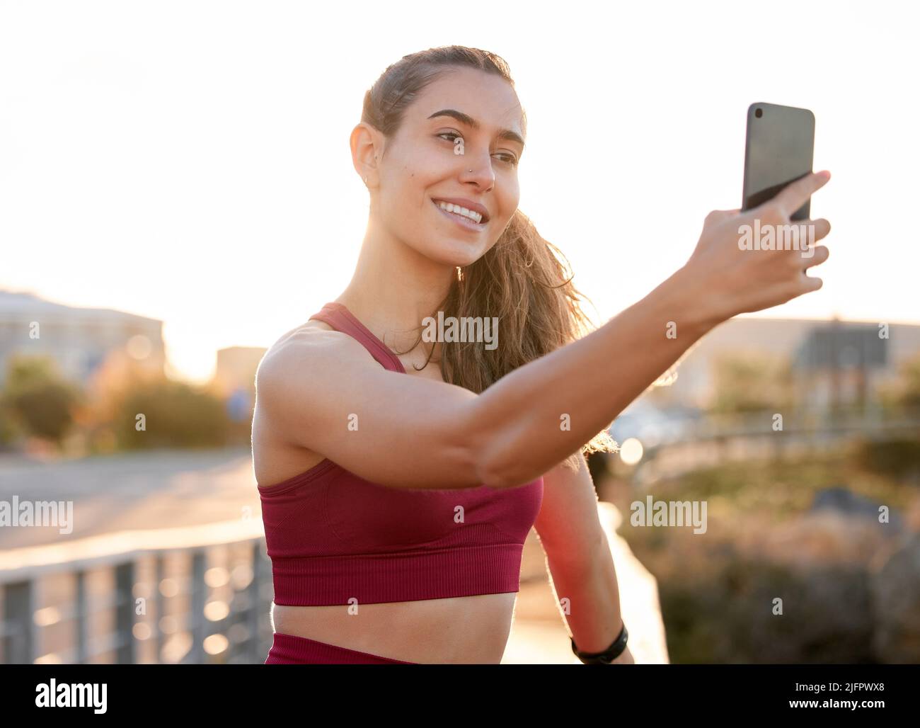 Mandatory workout selfie. Shot of a young woman taking a selfie while on a run outside Stock ...