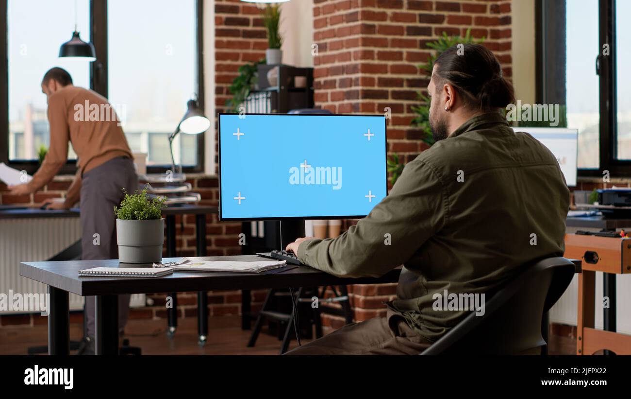 Office employee typing on computer with greenscreen, working with ...