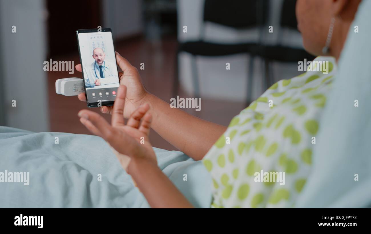 Close up of patient holding smartphone with video call, having remote ...