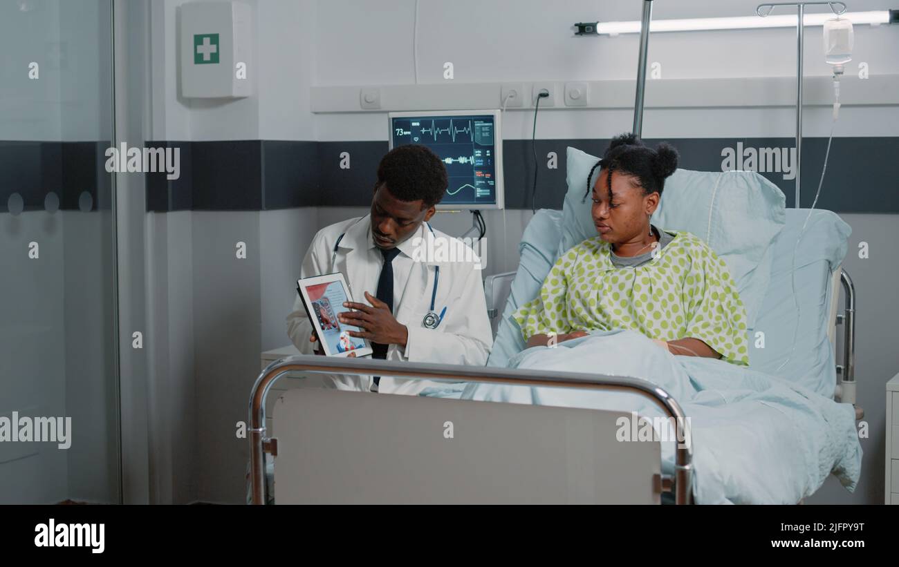 Man explaining cardiology diagnosis to patient with illness in bed ...