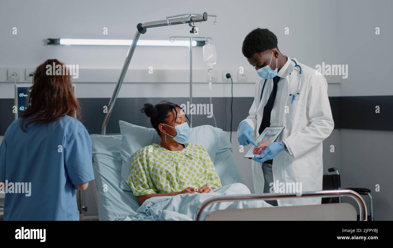 Medic explaining cardiovascular figure on digital tablet to patient ...
