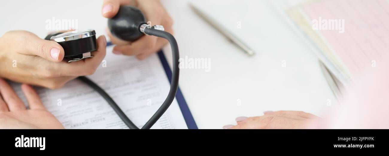 Doctor measuring patients blood pressure with tonometer tool in office ...