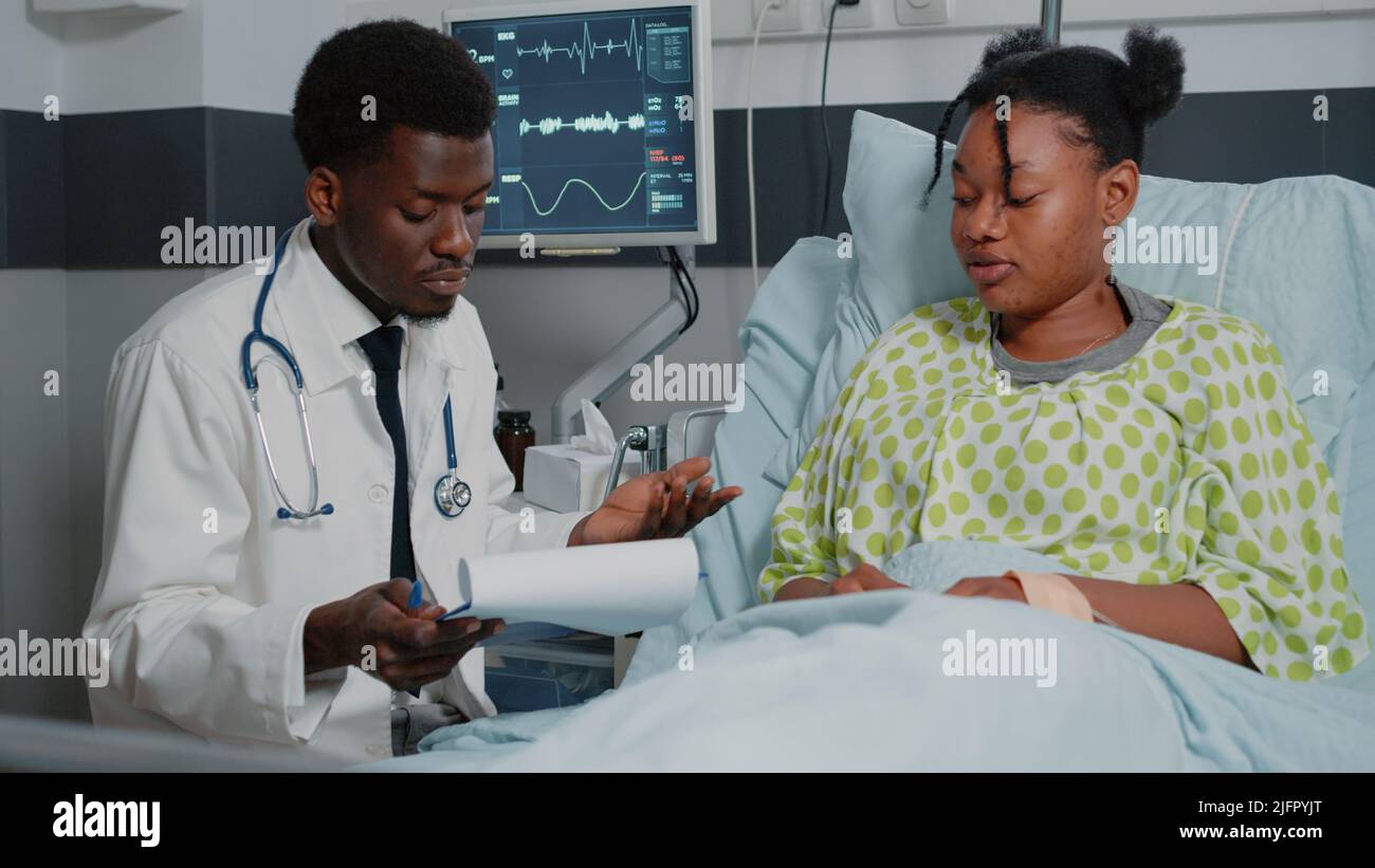 African american doctor consulting patient with IV drip bag. General ...