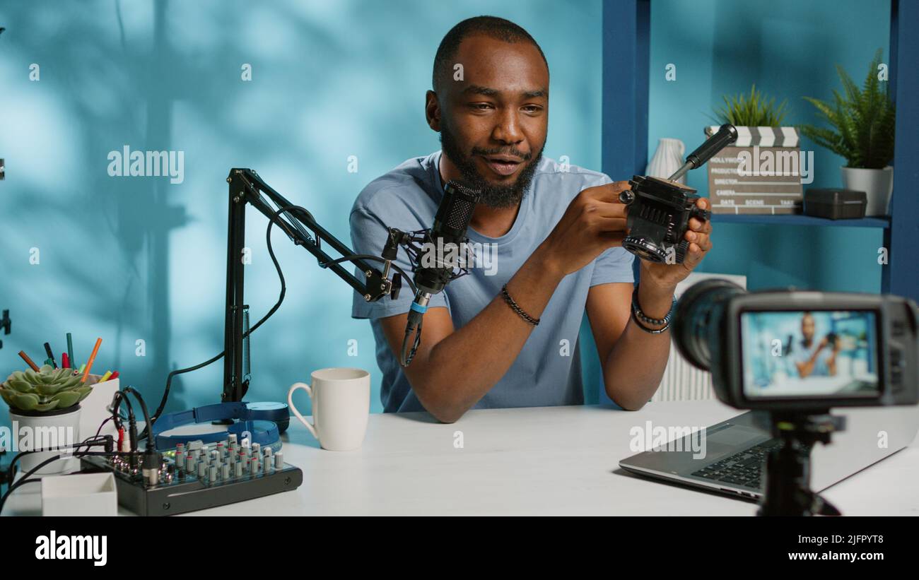 Social media vlogger reviewing tripod head for camera gear on podcast ...