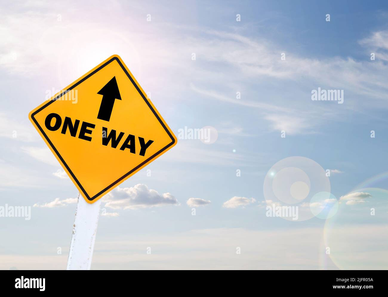 Text for ONE WAY on yellow road sign with blur blue sky background ...