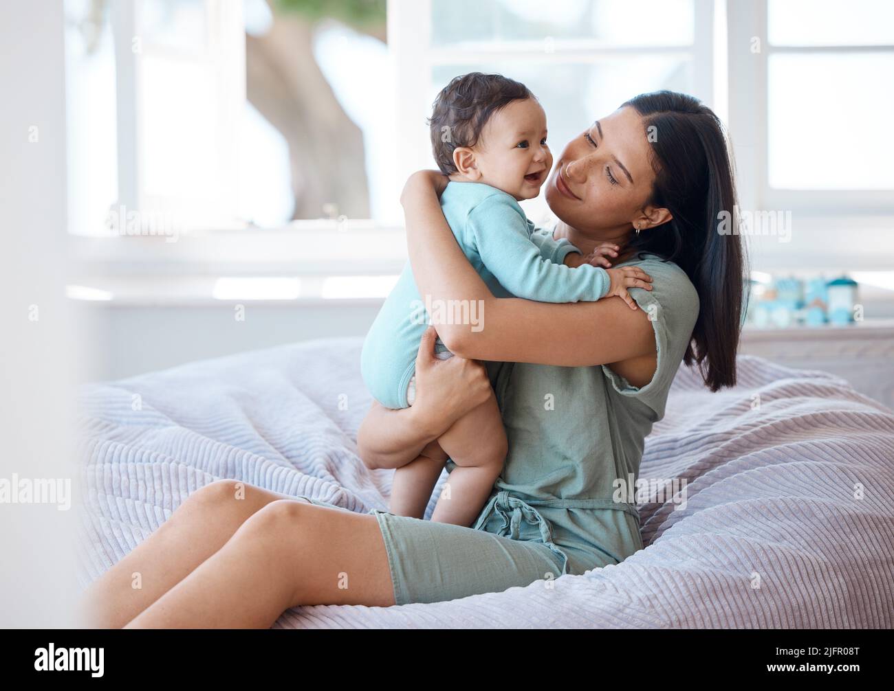 We can do cuddles all day. Shot of a mother bonding with her baby at ...