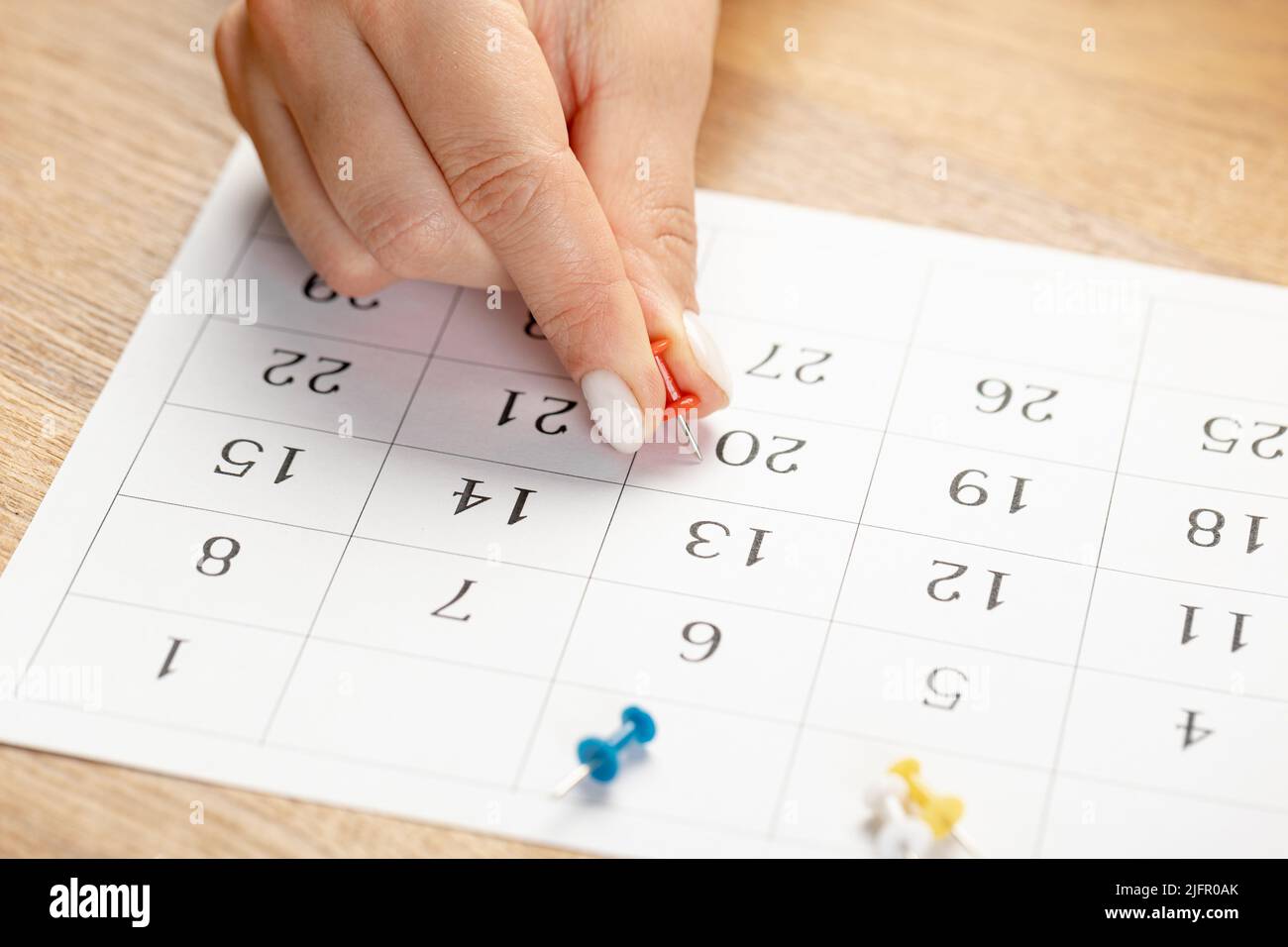 red Hand pin stuck on the day of the month in the calendar, business ...