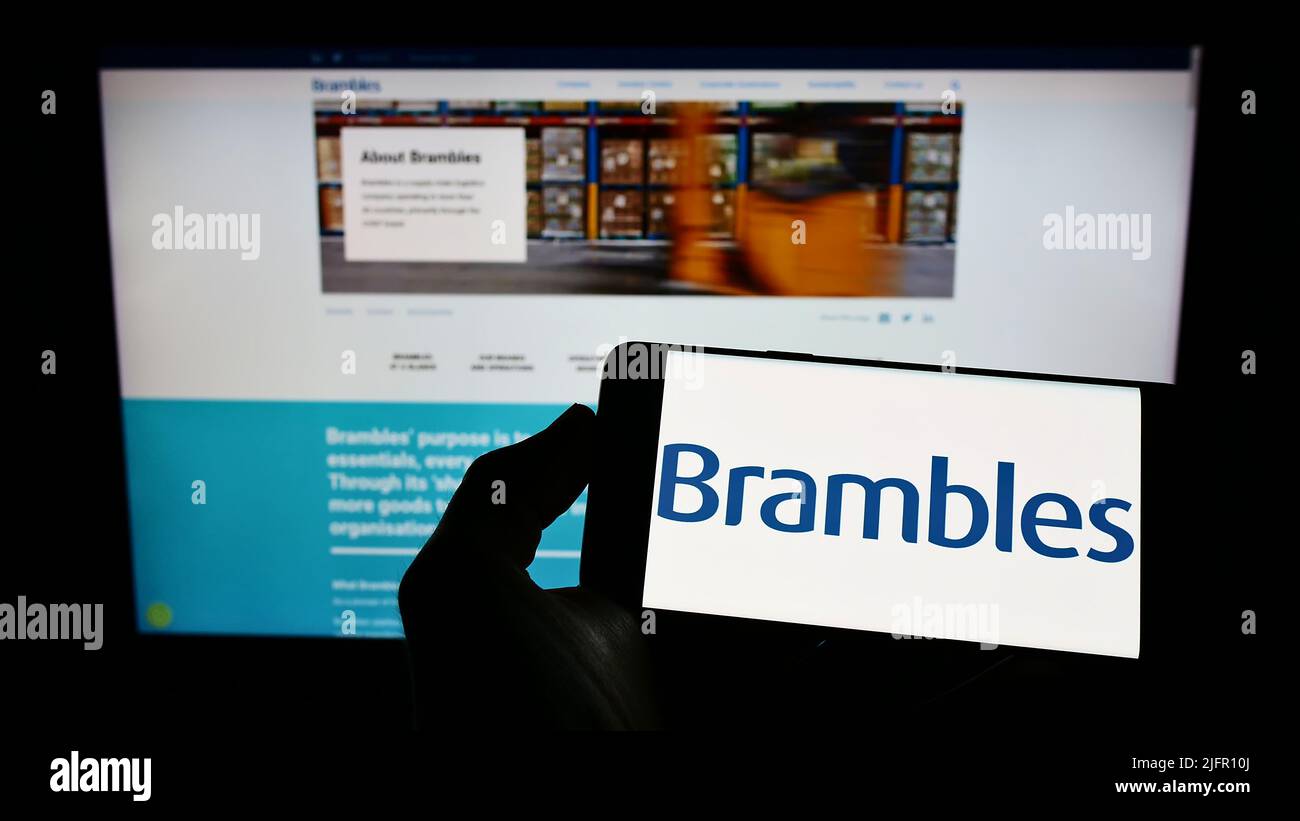 Person holding cellphone with logo of Australian services company ...