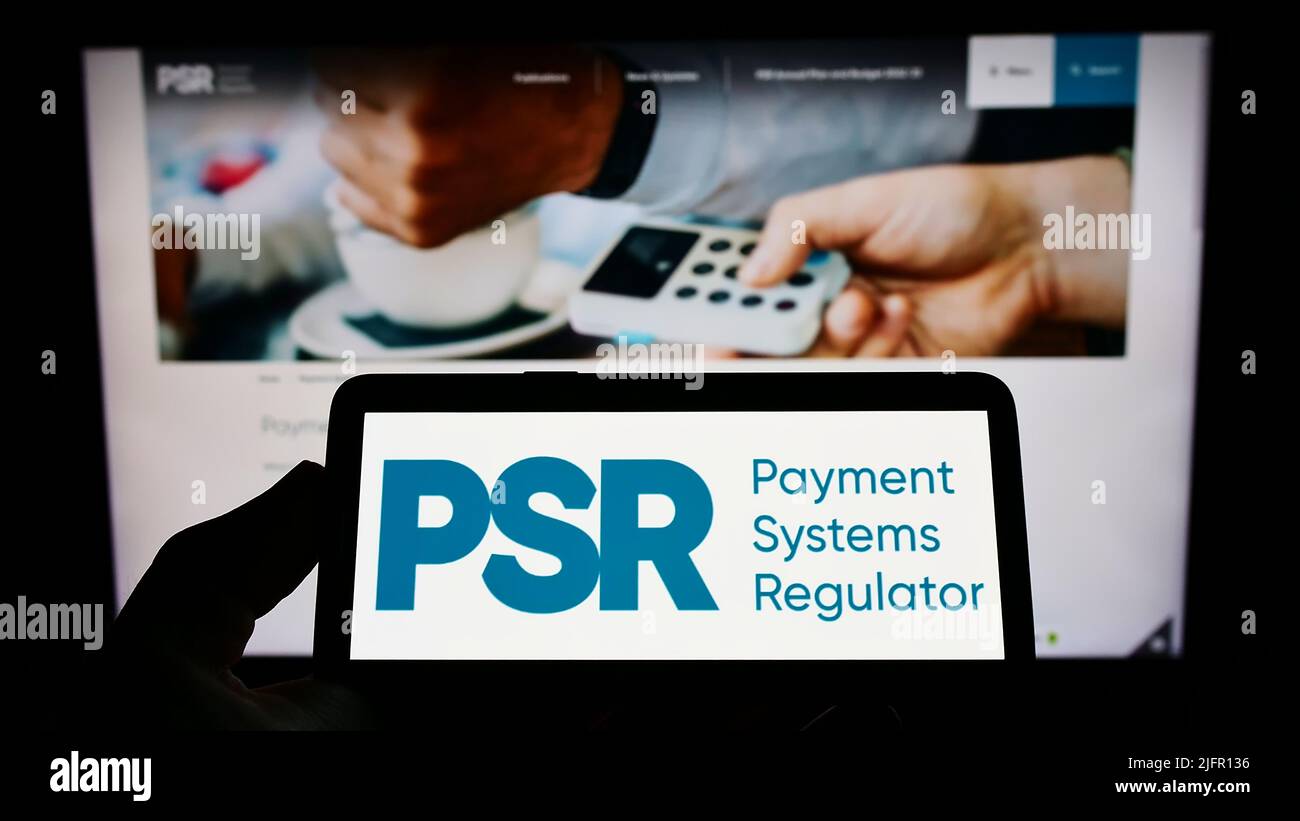 Person holding mobile phone with logo of British Payment Systems ...