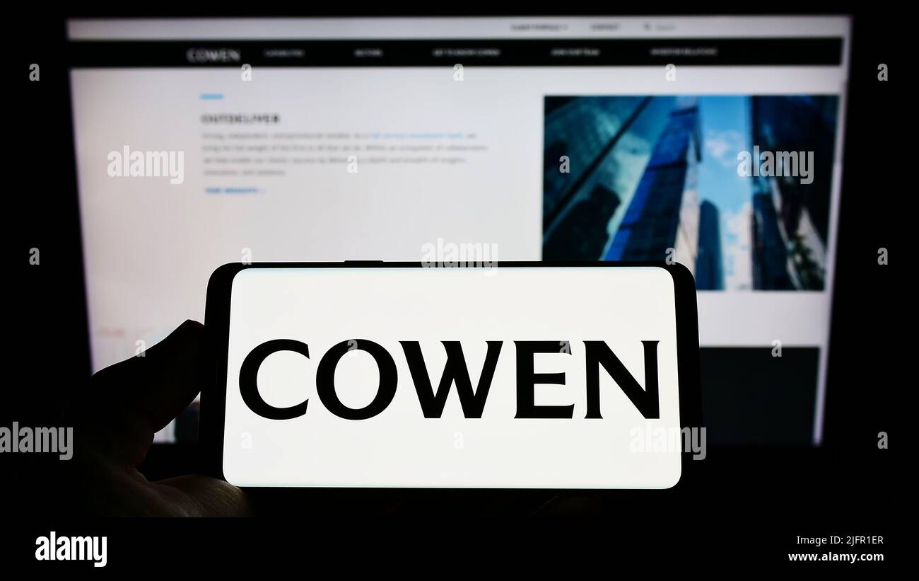 Person holding cellphone with logo of US investment banking company ...