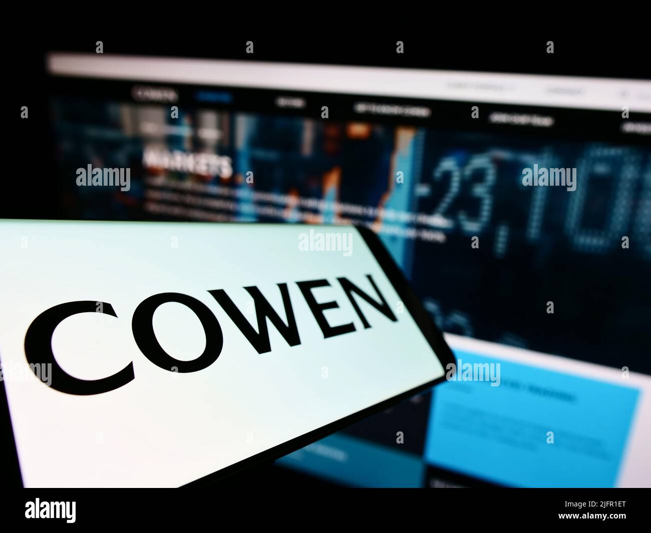 Mobile phone with logo of American investment banking company Cowen Inc ...