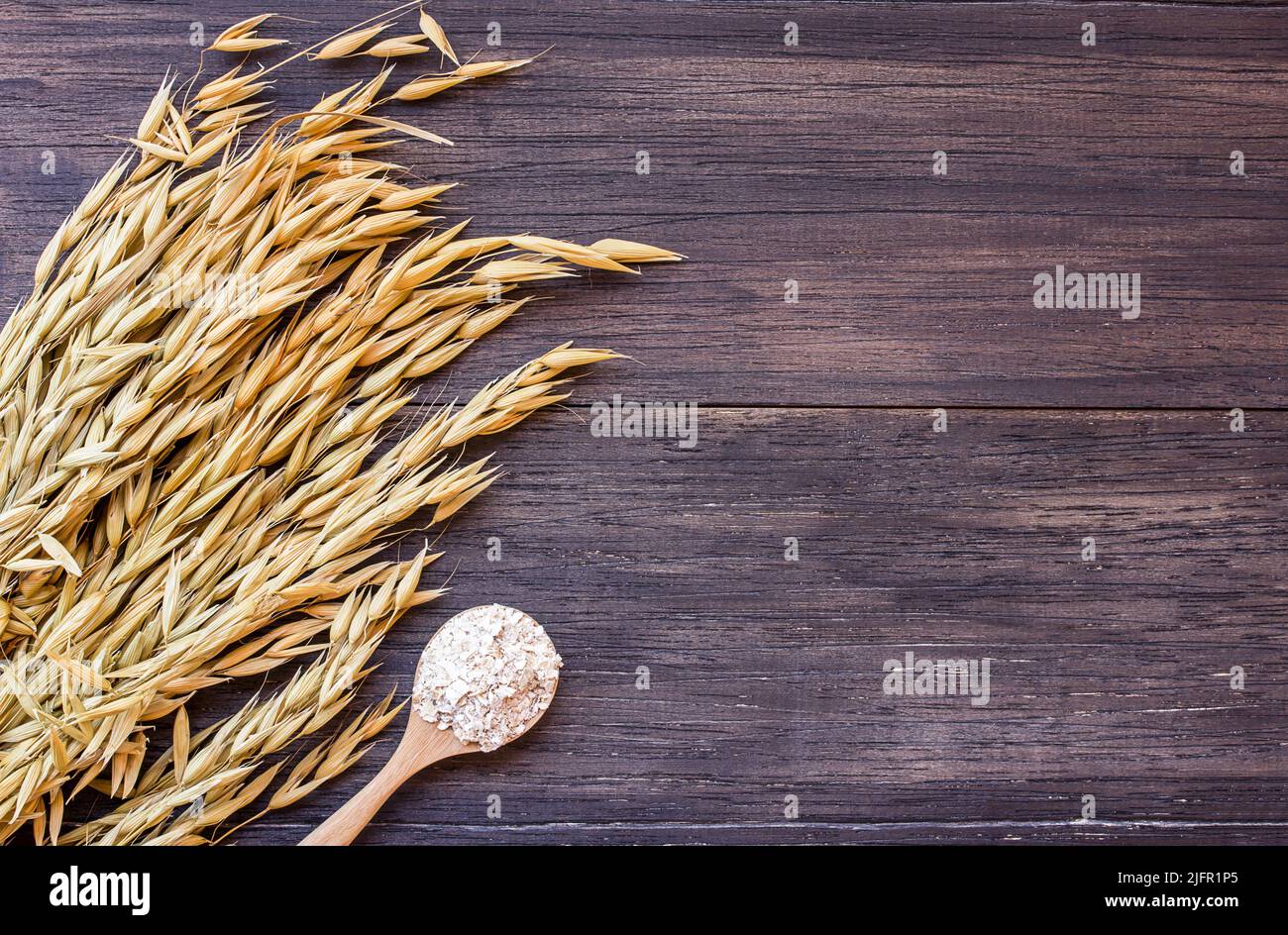 Rolled oats and oat ears of grain on a wooden table.ears of wheat on ...