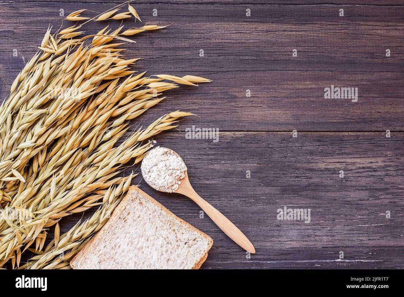 Rolled oats and oat ears of grain on a wooden table.ears of wheat on ...