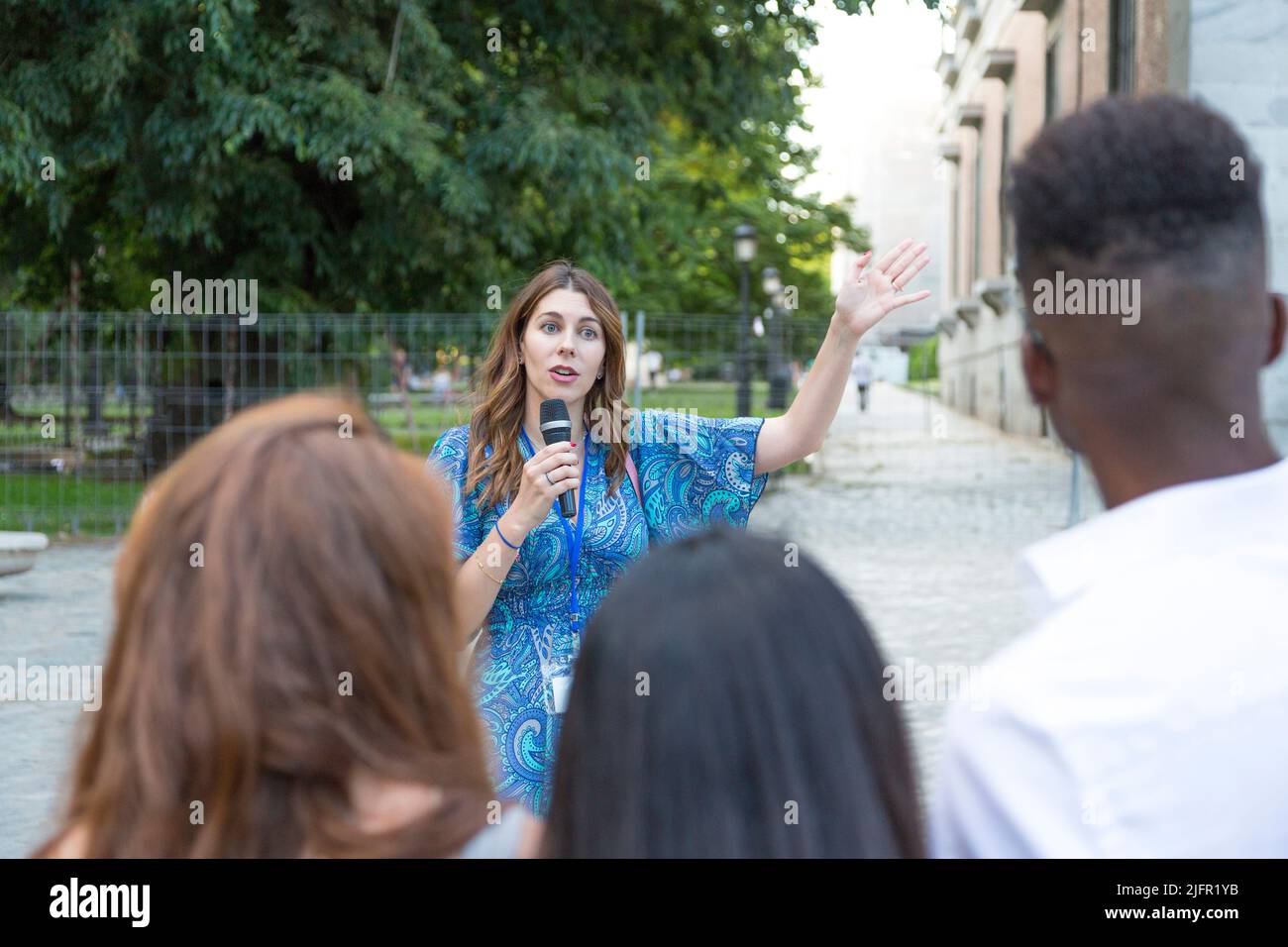 Focus on a tour guide talking to a group of tourists Stock Photo - Alamy