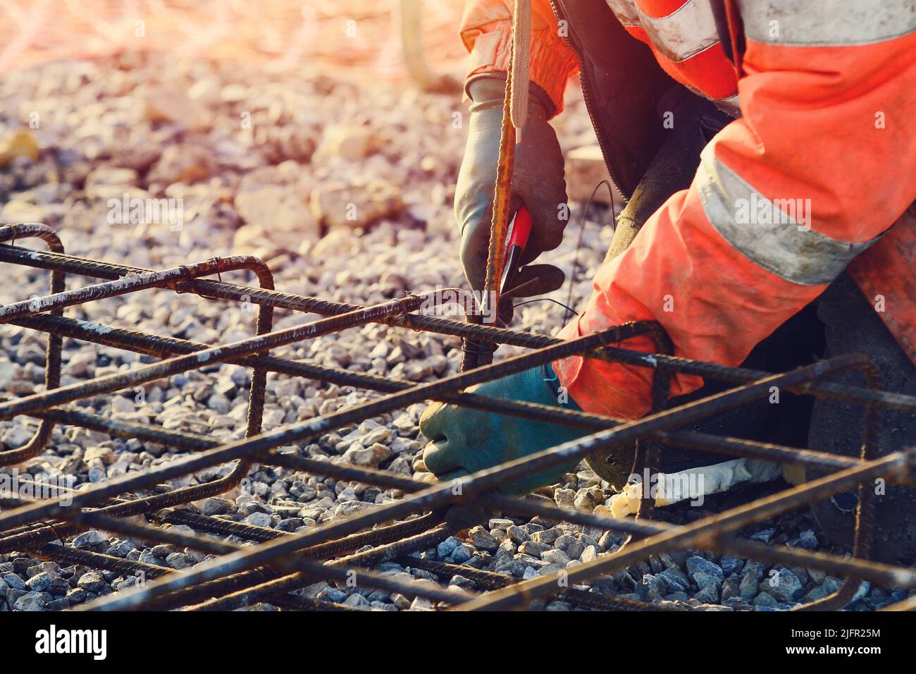 Builder's hands fixing steel reinforcement bars at construction site ...