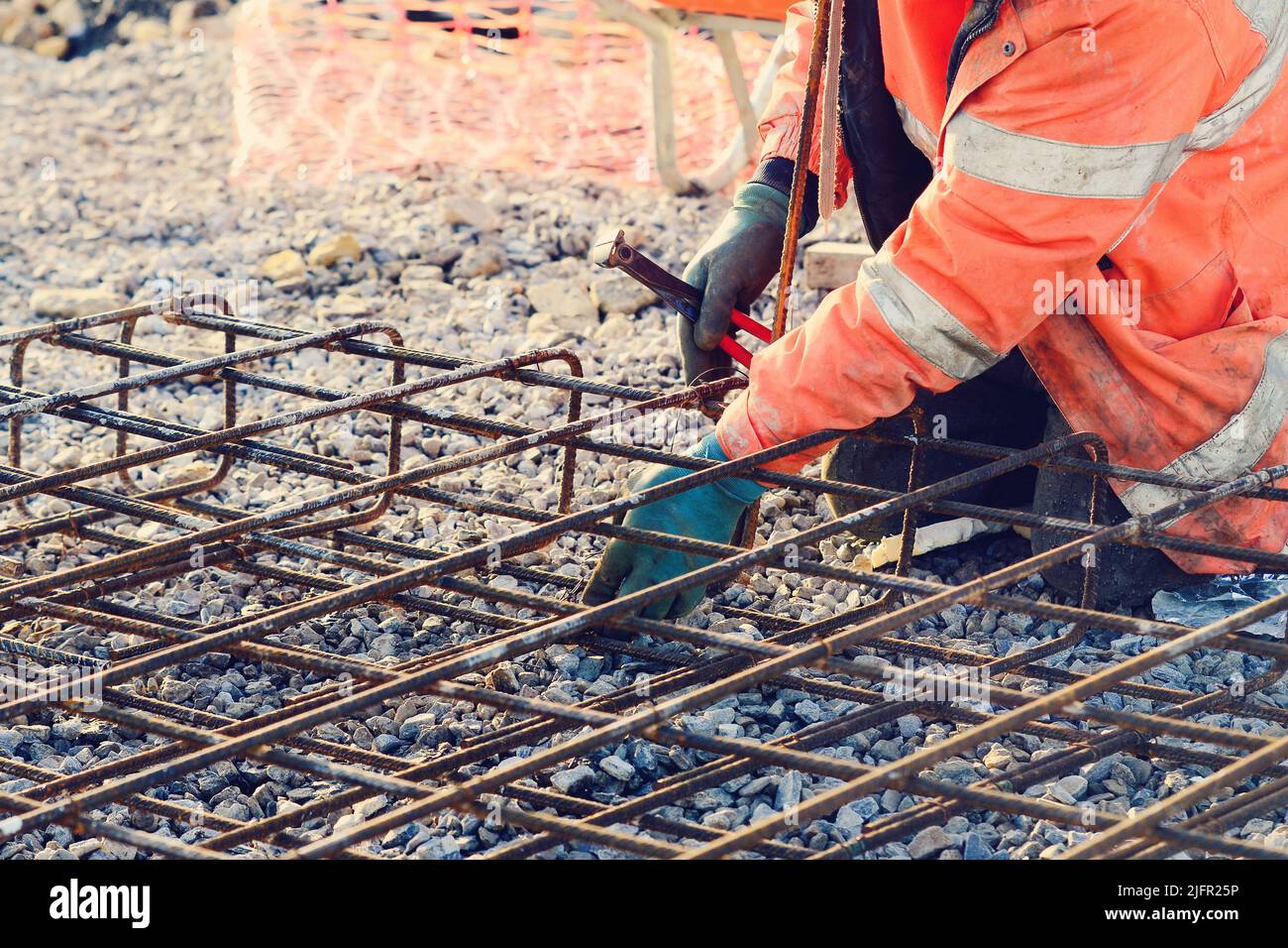 Builder's hands fixing steel reinforcement bars at construction site ...