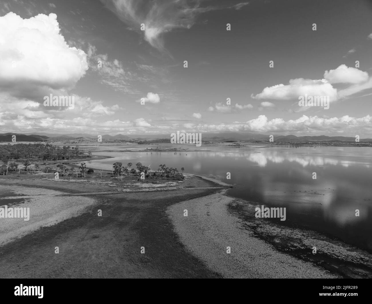Drone aerial above a patch of land in a dam surrounded by aquatic ...