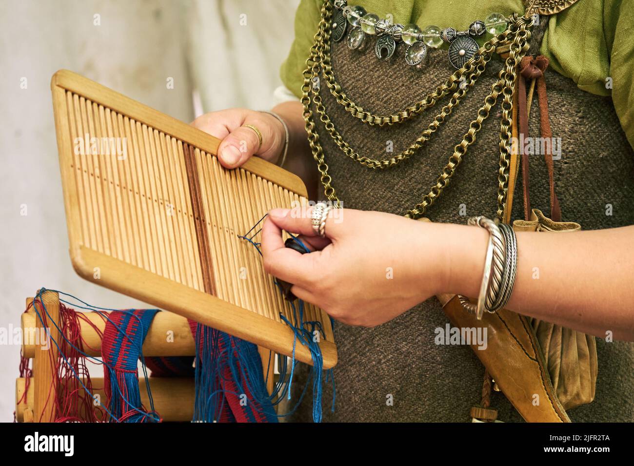 A woman in ancient Byzantine clothing makes yarn and sews from vintage ...