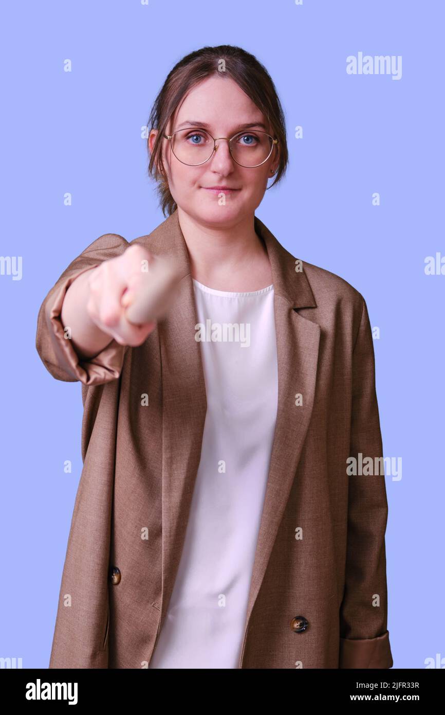 Smiling woman teacher showing with pointer forward on studio blue ...