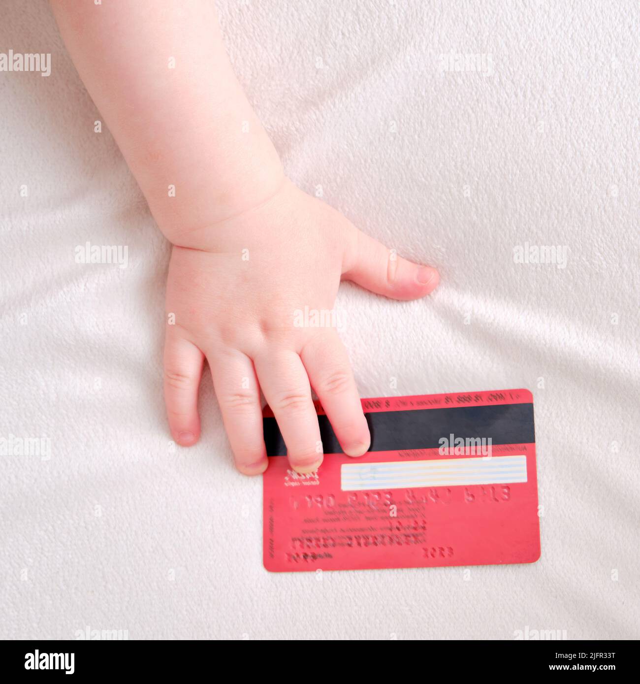 Baby toddler boy holds a credit card in his hand. Child with a bank ...