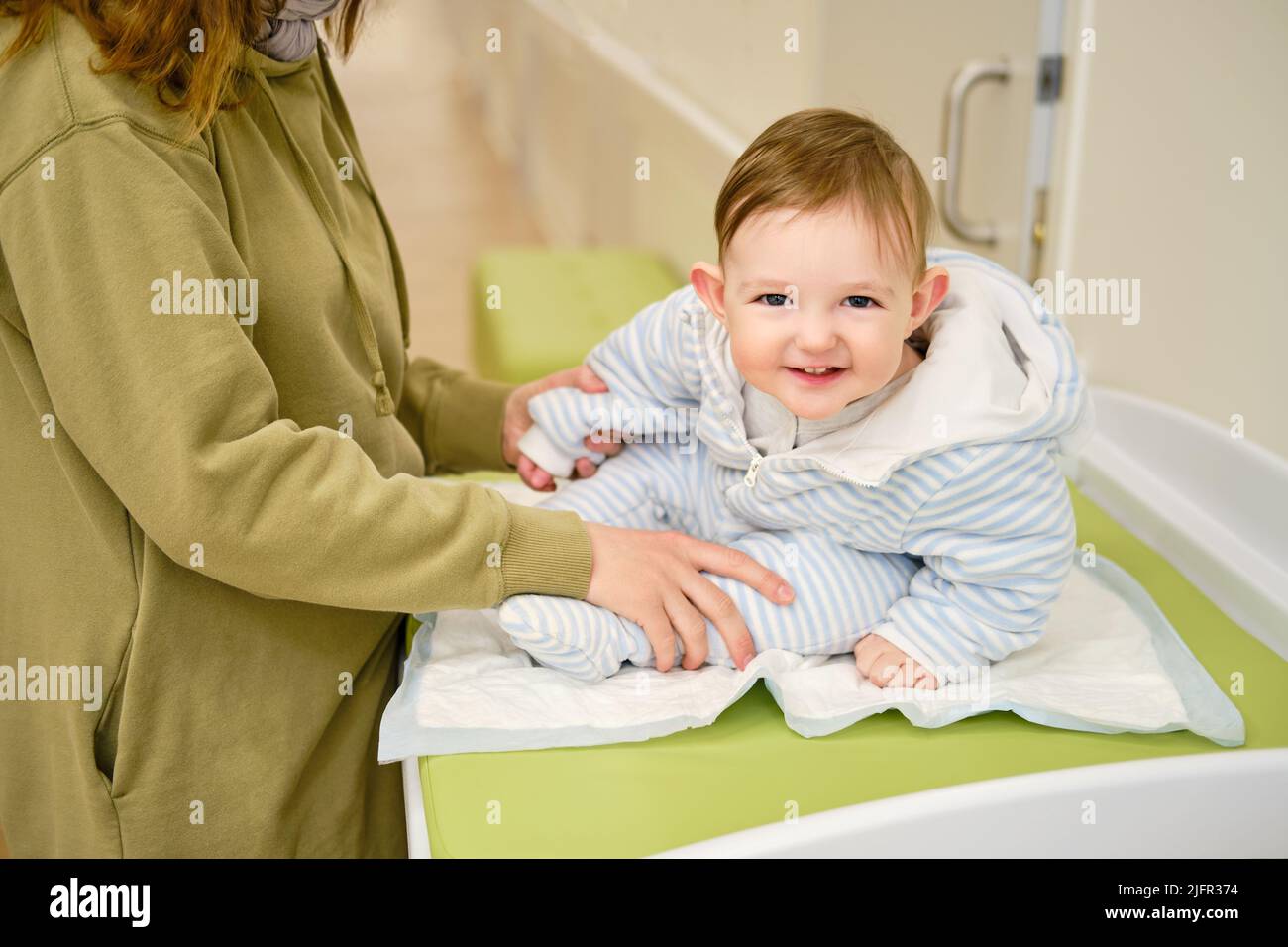 Mom with a child in the corridor of the hospital on the table for ...
