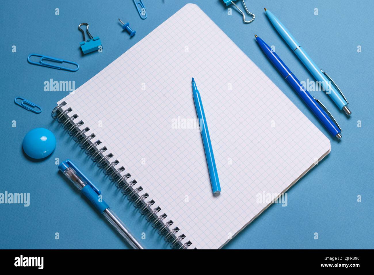 Stationery. Open notebook pencils and pens, stickers and binding clips ...