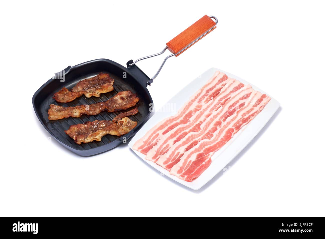 Grill Frying pan with cooked bacon rashers and raw slices on white ...