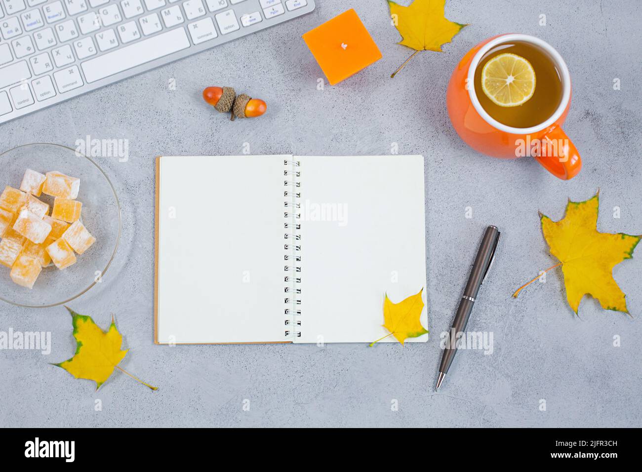 An open blank diary notebook, calendar with yellow leaves and tea ...