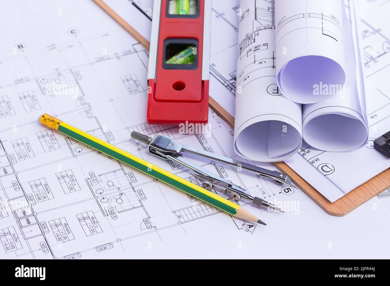Pencil and pencil compasses over a construction plan drawing for the ...
