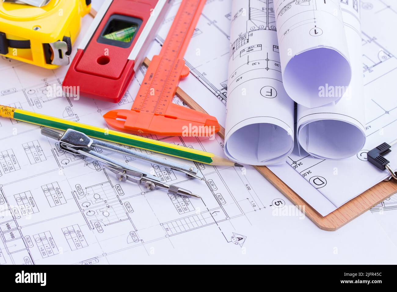 Architecture plan and rolls of blueprints with tool kit for the project ...