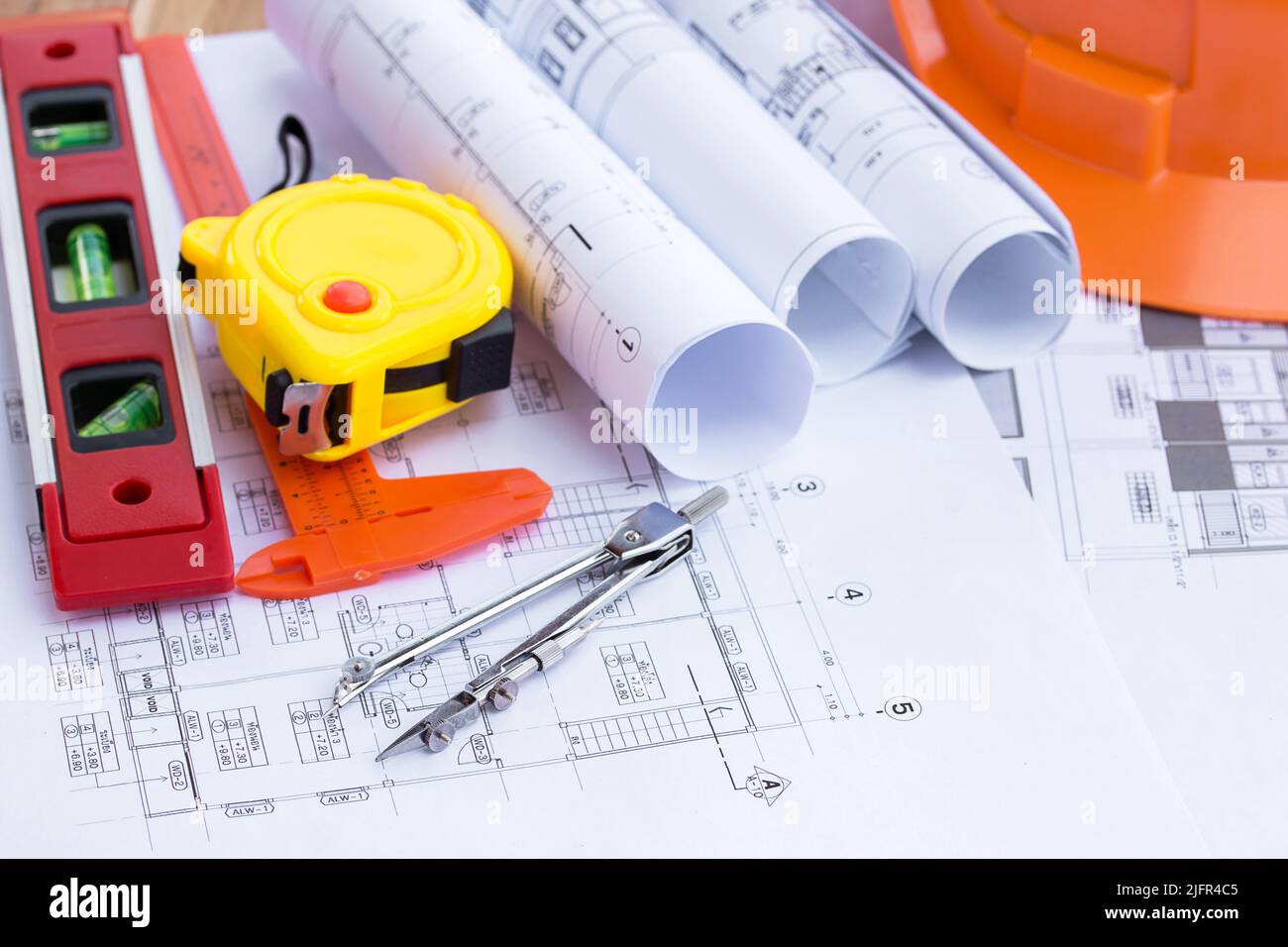 Architecture plan and rolls of blueprints with tool kit for the project ...