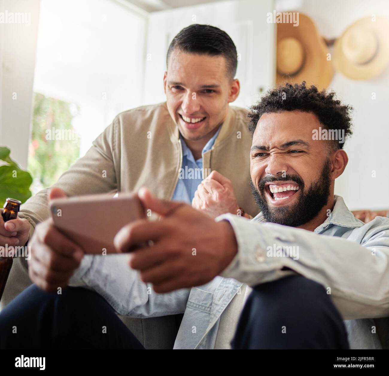 Check out this cool new app. Shot of two men laughing while looking at ...